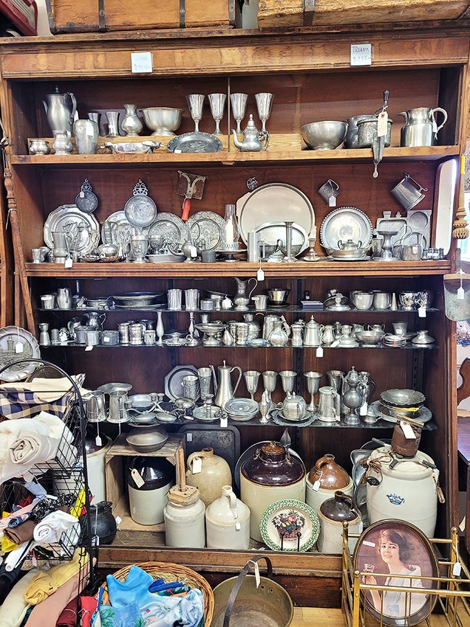 Silver and pewter treasures gleam under the lights, a metallic symphony of craftsmanship from eras when things were built to outlast their makers.