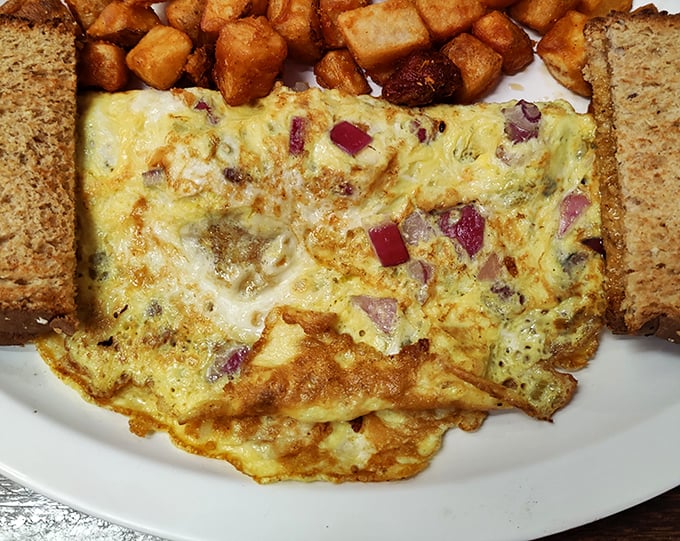 This omelet doesn't just contain ingredients; it embraces them in a fluffy egg blanket that's been perfected through countless morning shifts.