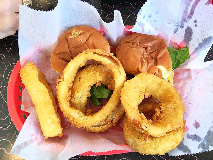 Golden-battered onion rings that shatter with each bite, paired with sliders that prove sometimes the best things come in small packages.