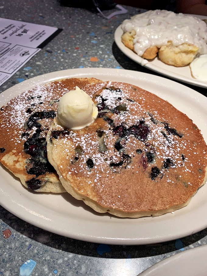 These blueberry pancakes aren't just breakfast&mdash;they're edible nostalgia, complete with melting butter and a dusting of powdered sugar that screams "weekend morning." 