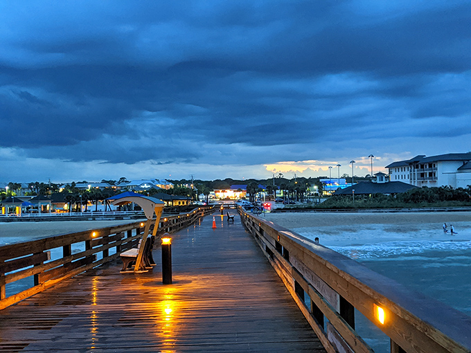 As twilight embraces the pier, strings of lights create a runway to the horizon. Even the fish below know this is prime-time dinner theater.