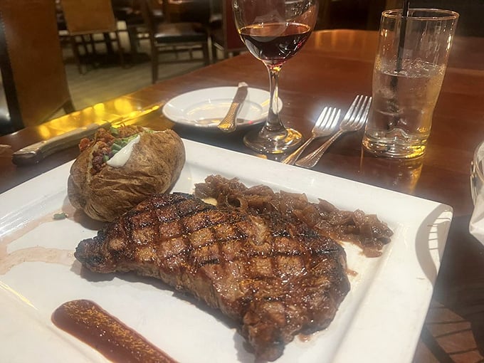 This is what dreams are made of, folks &ndash; a perfectly grilled ribeye with those coveted grill marks, a loaded baked potato, and a glass of red that's practically winking at you.