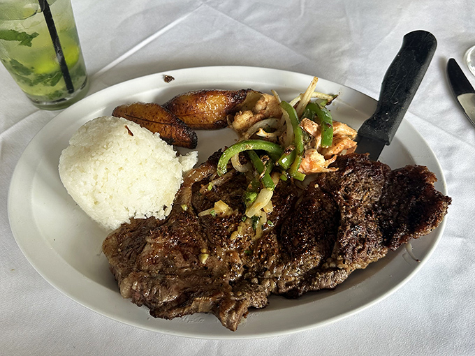 Behold the legendary skirt steak in its natural habitat—perfectly charred, accompanied by white rice and sweet plantains. This is what food dreams are made of.