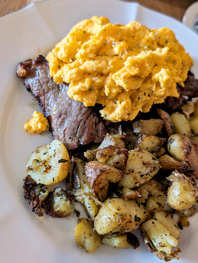 This isn't just breakfast; it's a morning masterpiece with perfectly seared steak, fluffy scrambled eggs, and herb-roasted potatoes.