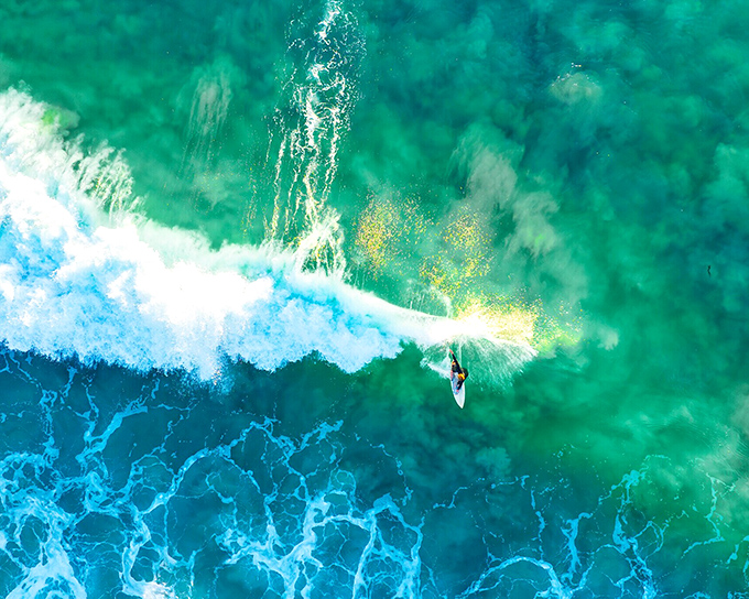 A lone surfer carves through translucent turquoise waters, demonstrating why Dana Point has been a surfing mecca since long before Instagram made it trendy.