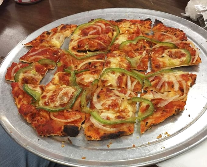 Green peppers and onions arranged with artistic precision on that signature cracker-thin crust—proof that vegetables can be just as indulgent as their meaty counterparts.