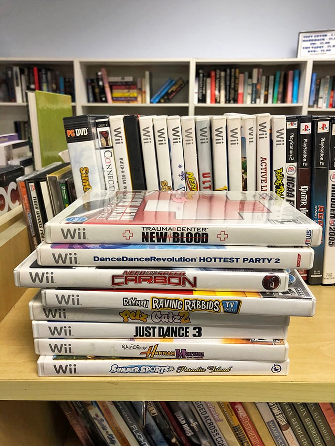 The electronics corner reveals a stack of Wii games that will transport you back to when "Just Dance 3" was the reason your living room furniture got rearranged.