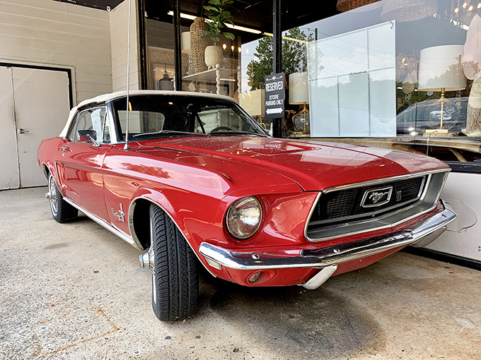 Classic American muscle meets antique shopping. This cherry-red vintage Mustang proves that sometimes the merchandise outside is just as impressive as what's inside.