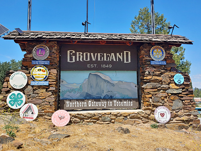 Groveland's welcome sign proudly announces its 1849 founding, surrounded by community club emblems like merit badges on a Sierra Nevada scout's uniform.