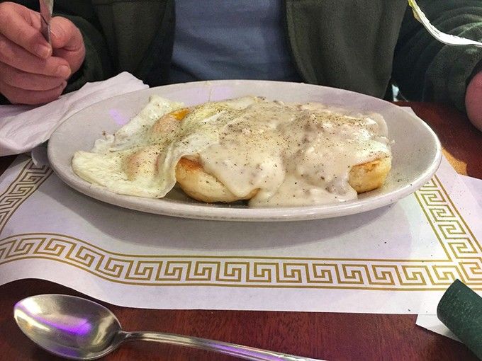 These legendary biscuits arrive drowning in creamy sausage gravy that could make even the grumpiest morning person smile.