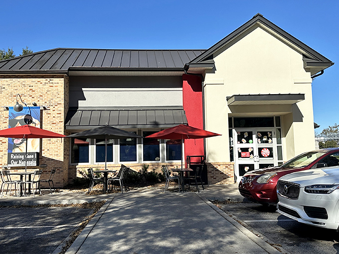 Raising Cane's brick-and-cream building with cheerful umbrellas&mdash;where chicken fingers get the gourmet treatment they deserve.