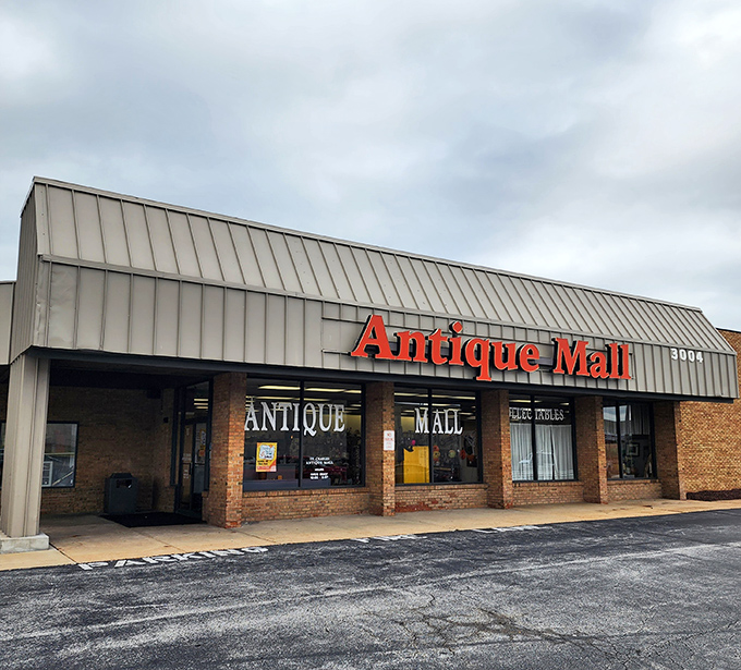 The red "Antique Mall" sign beckons like a lighthouse for treasure hunters navigating suburban shopping strips.