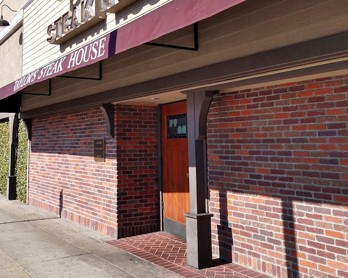 Classic brick exterior promises old-school steakhouse excellence hidden behind these traditional wooden doors.
