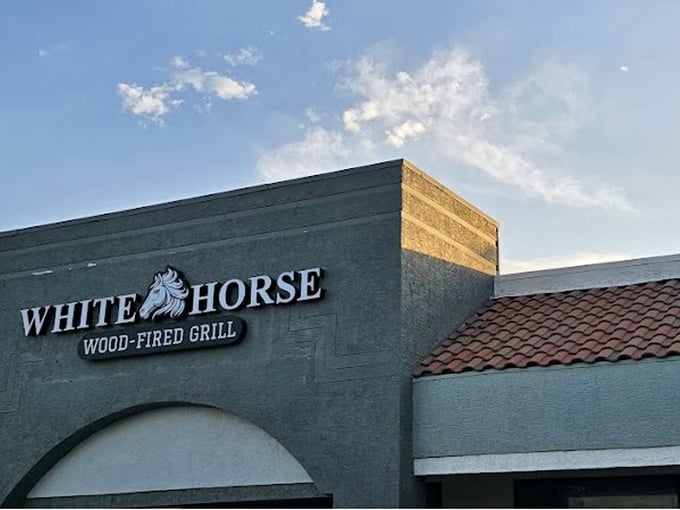 The White Horse sign promises what lies within: a wood-fired experience that elevates steak from mere food to memorable occasion.