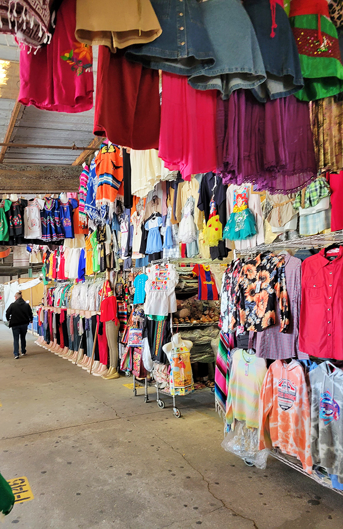 Clothing displays create a textile jungle where fashion treasures hide in plain sight. The thrill of the hunt is real!