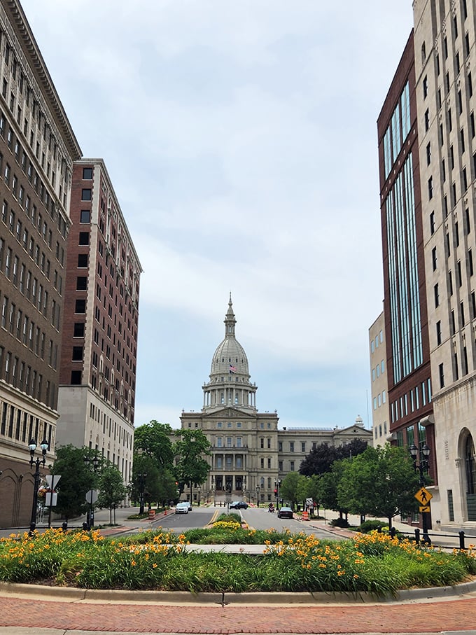 The grand view down Capitol Avenue showcases Lansing's impressive government buildings surrounded by lush landscaping and urban amenities.