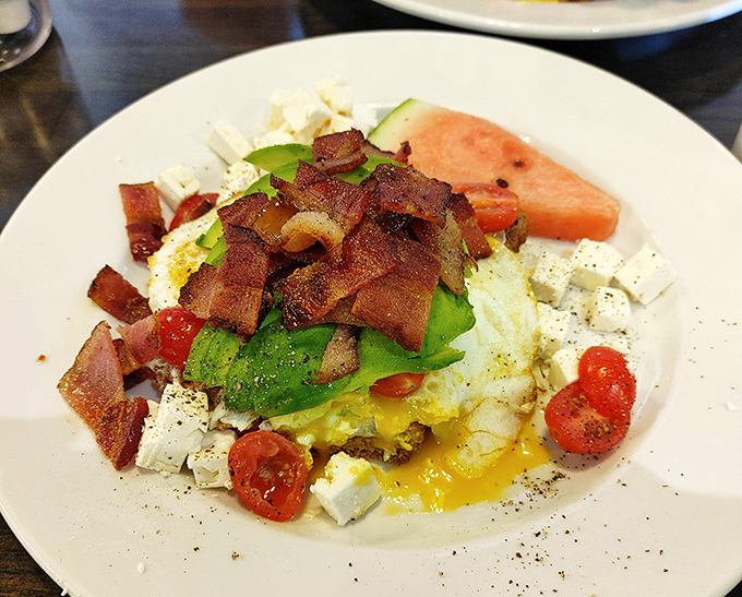 Avocado toast gets the royal treatment with bacon, feta, and enough toppings to share (but you won't).