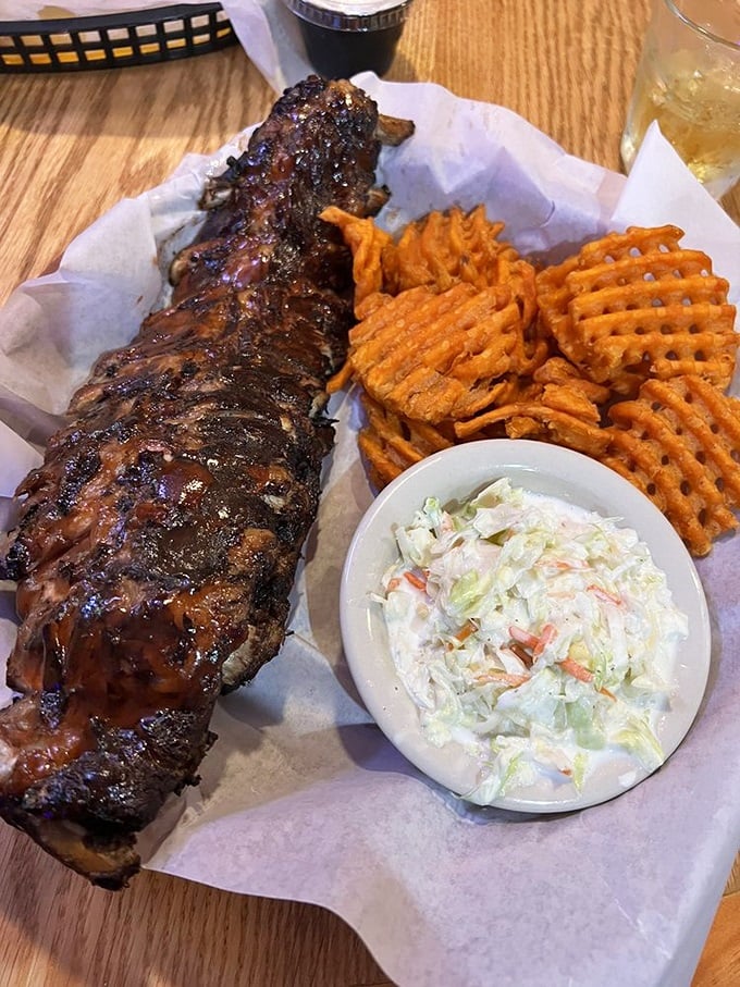 Baby back ribs with that perfect char, sweet potato waffle fries, and coleslaw – the holy trinity of barbecue that would make even vegetarians question their life choices.