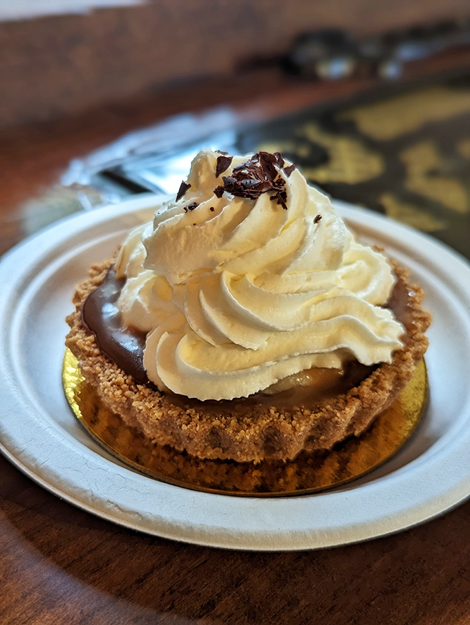 The Banoffee tart arrives like a cloud of cream atop chocolate decadence&mdash;proof that heaven exists and it's served on a gold-rimmed plate.