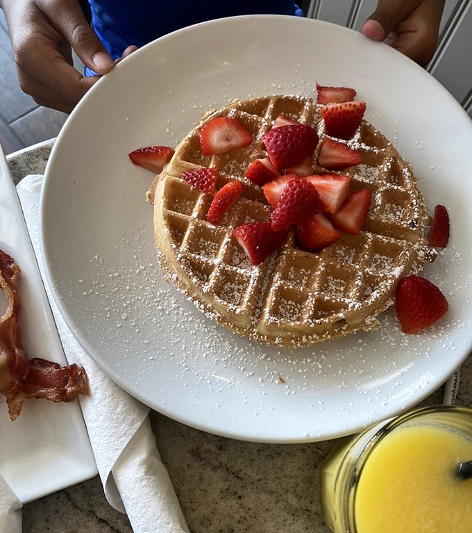 A Belgian waffle that's dressed for success with fresh strawberries and a dusting of powdered sugar. Breakfast or dessert? Why choose?