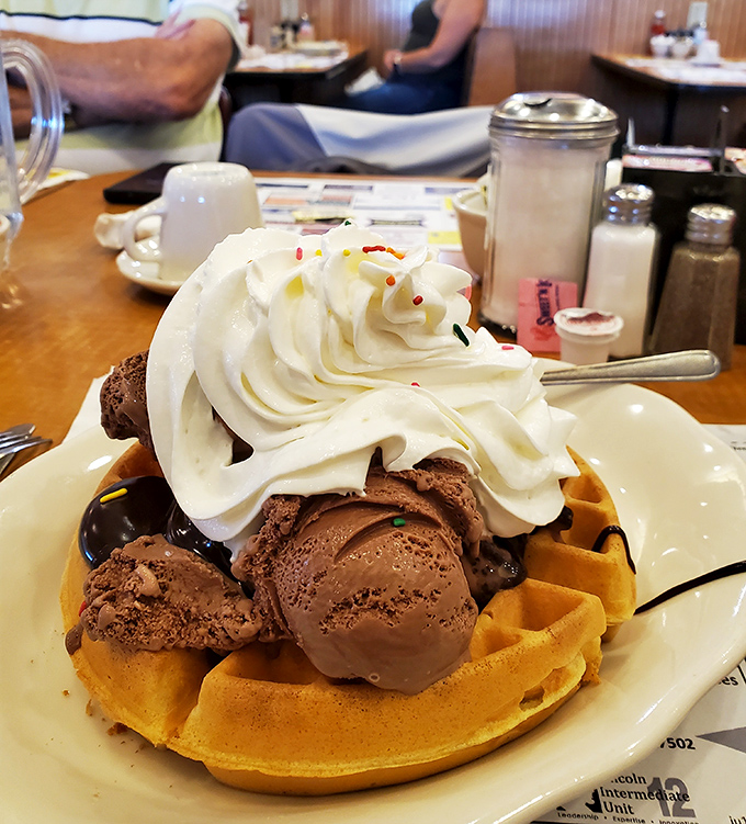 Dessert or breakfast? Why choose when this Belgian waffle sundae offers the best of both worlds with a mountain of whipped cream.
