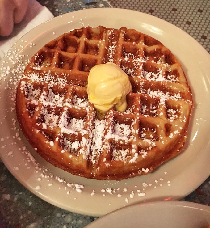 The Belgian waffle arrives like royalty, golden-crowned with butter slowly melting into those perfect squares&mdash;a breakfast that demands to be savored.