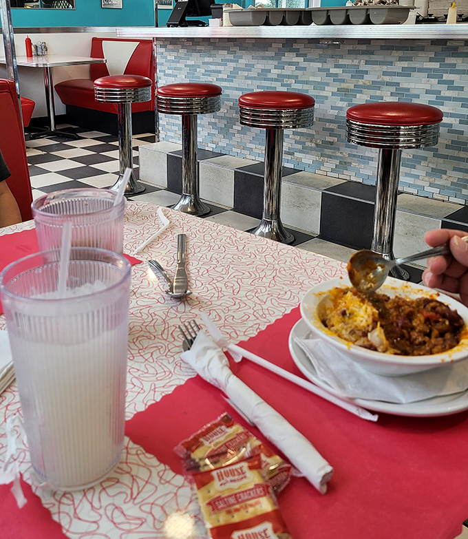Those classic chrome counter stools aren't just seating—they're front-row tickets to the greatest show on earth: watching your comfort food being prepared to perfection.