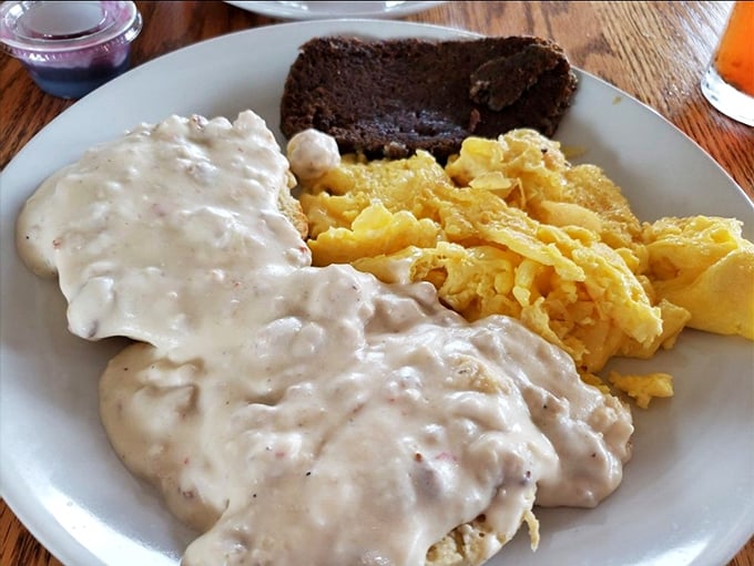 Biscuits drowning happily in creamy sausage gravy alongside golden scrambled eggs&mdash;Southern comfort that doesn't judge you for wanting seconds.