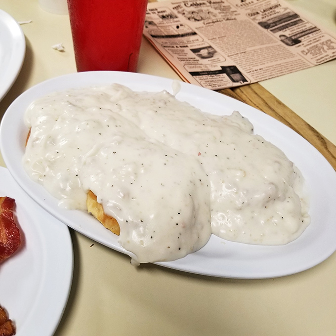 Biscuits swimming in creamy pepper-flecked gravy&mdash;a Southern baptism that transforms ordinary mornings into memorable ones. Resistance is futile.