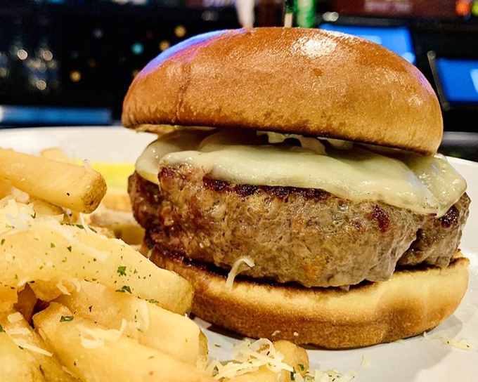 A burger that demands two hands and your full attention. The melted cheese cascades down sides that have been seared to textbook perfection.