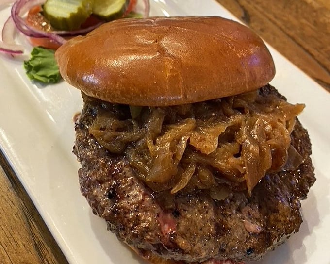 Caramelized onions crown this magnificent bison burger like a savory tiara &ndash; proof that sometimes the best accessories are edible.