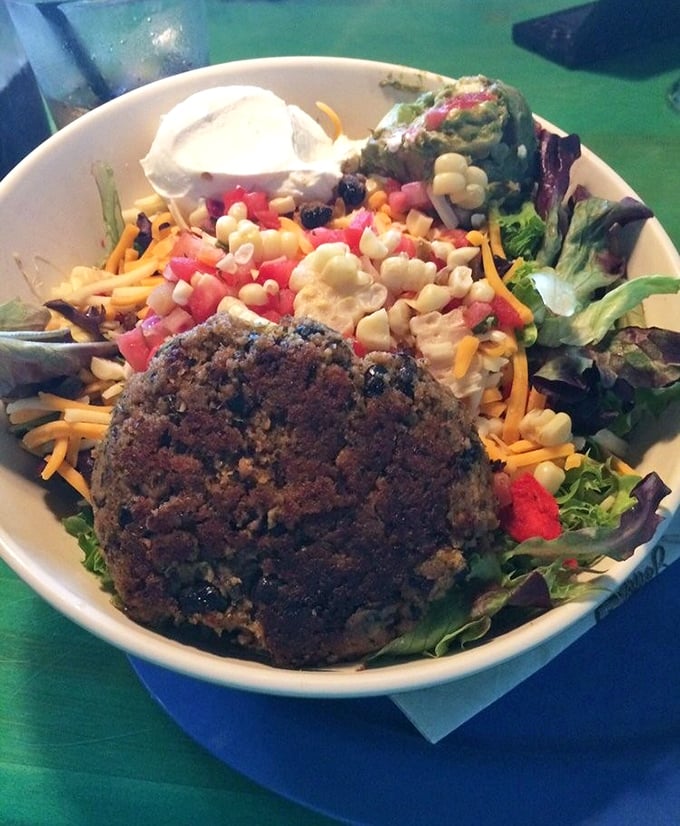 Not just a token vegetarian option, Big Billy's black bean burger stands proudly alongside its meaty counterparts on this colorful salad canvas.