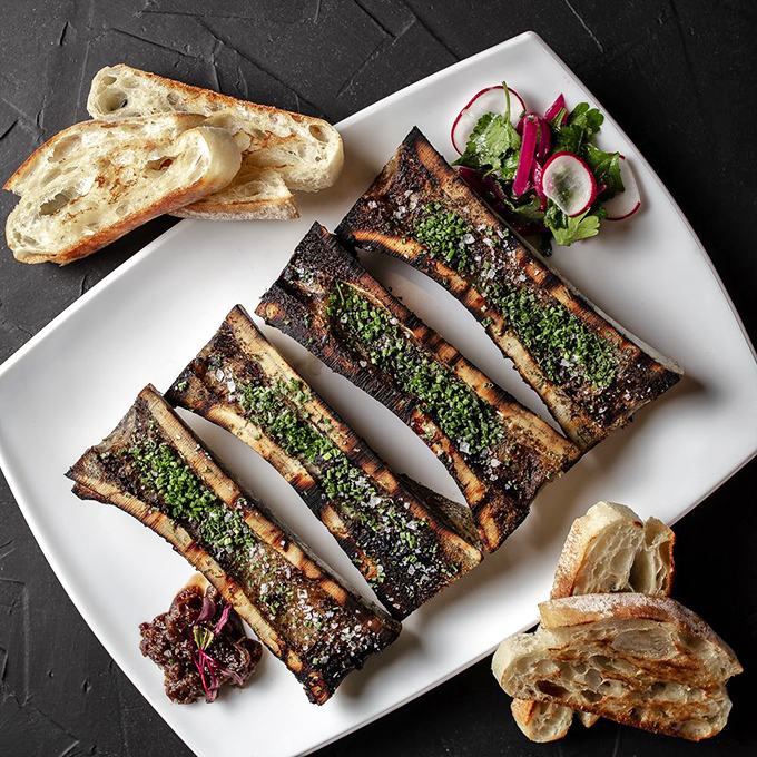 Bone marrow: nature's butter served in its original packaging. Those charred bones deliver silky, rich decadence that makes regular butter seem like it's not even trying.