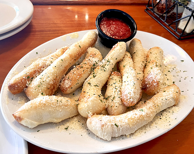 These breadsticks aren't just appetizers; they're warm, herb-dusted magic wands that make marinara sauce disappear with alarming speed.