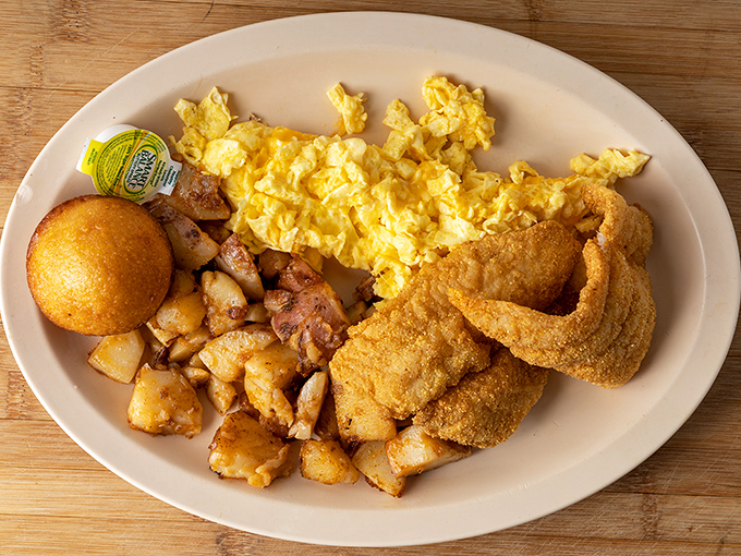 Breakfast perfection on a plate: golden potatoes with just the right crisp, fluffy scrambled eggs, and cornmeal-crusted catfish that would make any angler proud.