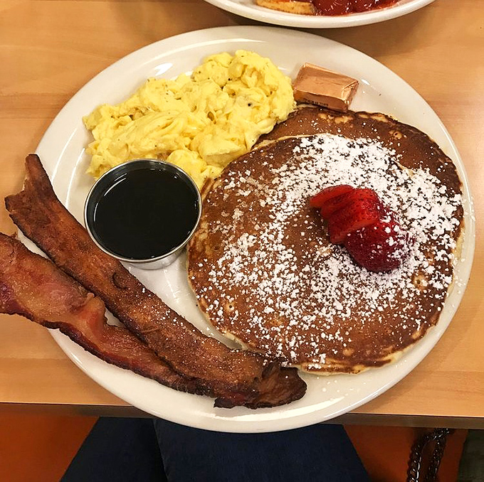 The breakfast trinity: fluffy pancakes, perfectly scrambled eggs, and bacon that strikes the ideal balance between crispy and chewy. The holy grail of morning meals.