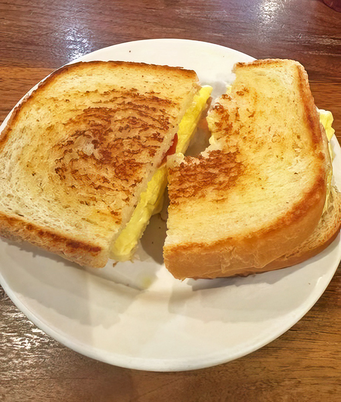 This breakfast sandwich isn't just food; it's edible architecture. Perfectly toasted bread supporting the weight of melty cheese and golden eggs.