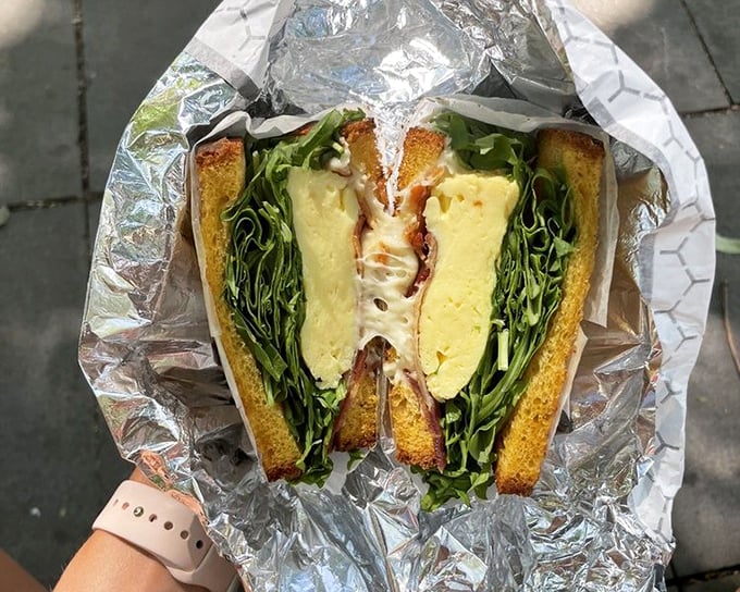 This isn't just a sandwich&mdash;it's architecture. Layers of fresh ingredients nestled between perfectly toasted bread, with greens adding both color and conscience.