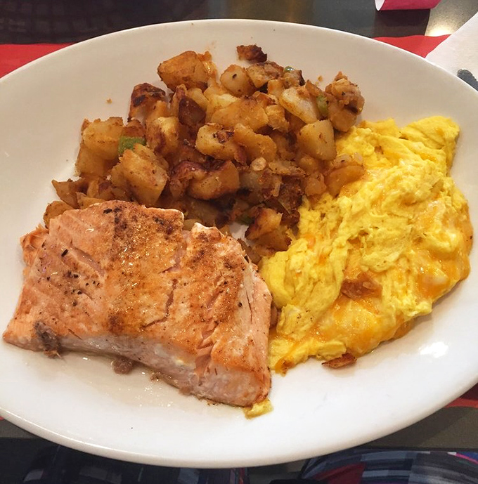 Breakfast trinity: perfectly seared ham steak, scrambled eggs that actually taste like eggs, and home fries that could make a potato proud.