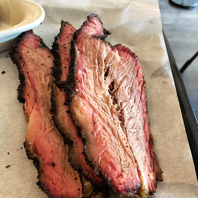 Brisket with that perfect pink smoke ring isn't just meat&mdash;it's edible evidence of patience, skill, and barbecue devotion that transcends state lines.