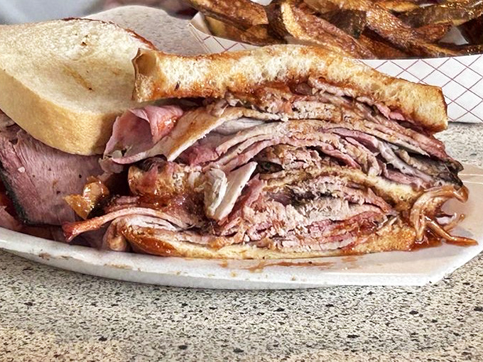 This isn't just a sandwich; it's an architectural marvel of stacked brisket that requires both hands and possibly a nap afterward.