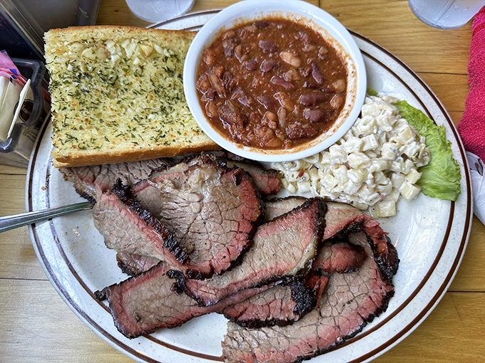 Brisket slices with that telltale smoke ring, beans that didn't come from any can, and garlic bread that refuses to be an afterthought.