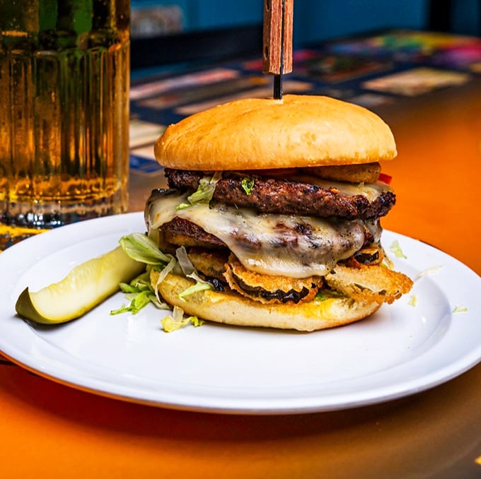 Not just a burger, but a towering achievement of beef architecture that requires both hands and possibly an engineering degree.