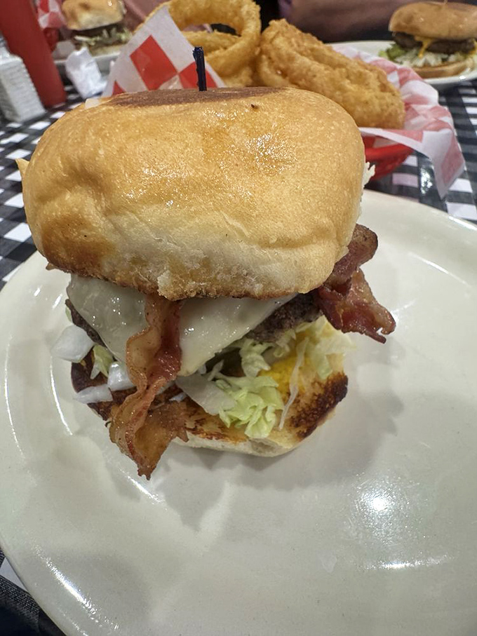 This isn't just a burger; it's a structural engineering marvel with bacon cascading like a waterfall of pork perfection.
