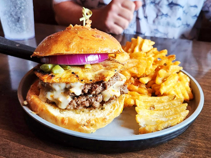 This isn't just a burger&mdash;it's architecture. Layers of beef, cheese, and toppings create a savory skyscraper that demands both admiration and a strategic eating plan.