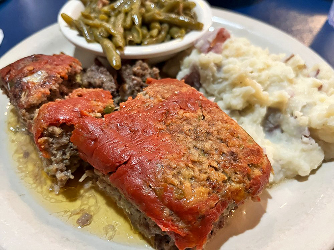 Meatloaf that would make your grandmother both jealous and proud, swimming in savory gravy alongside classic Southern sides.
