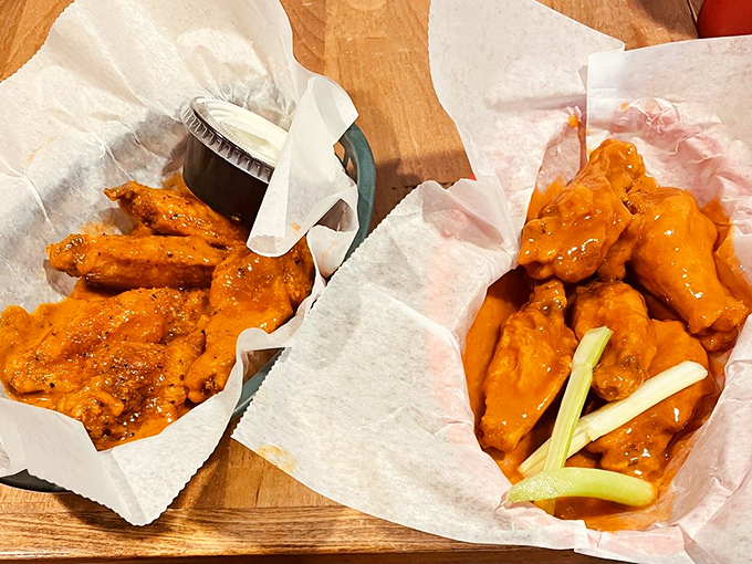 Orange you glad these wings exist? Two baskets of saucy perfection with the traditional celery garnish—nature's way of pretending wing feasts are balanced meals.