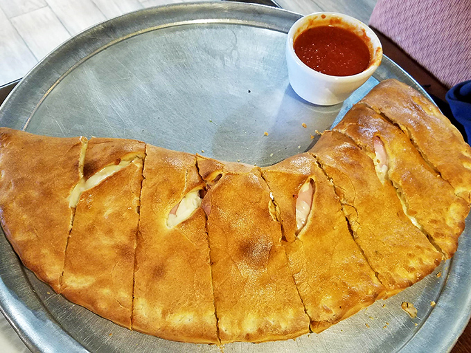 This calzone isn't just folded pizza – it's a golden-brown treasure chest filled with molten cheese and savory fillings. Marinara for dipping required!