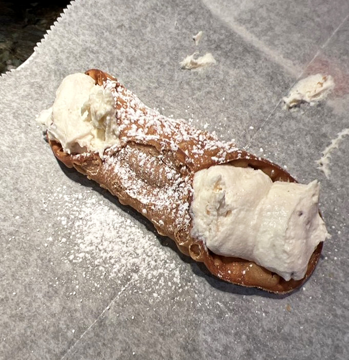This cannoli isn't just dessert&mdash;it's the exclamation point at the end of a perfect meal. Crisp shell, creamy filling, and a dusting of powdered sugar dreams.
