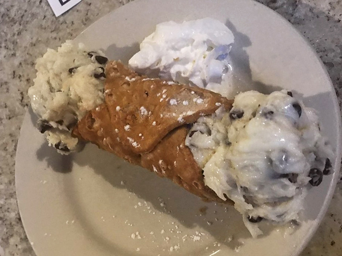 Not just dessert, but a religious experience: crispy shell, creamy filling, and a dusting of powdered sugar perfection.